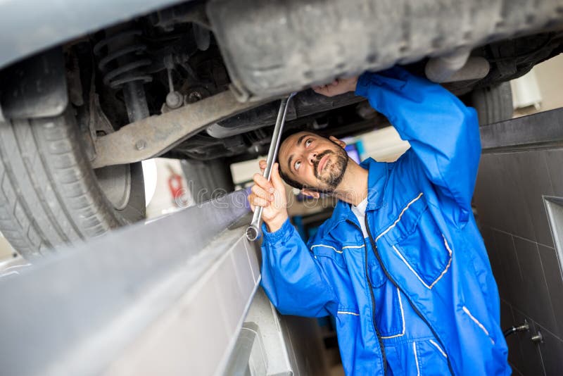 Mechanic under the car stock image. Image of overalls - 60301833