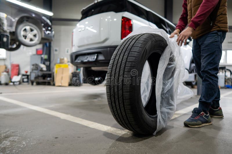 Mechanic Unpacking New Tires in a Garage. Stock Image - Image of change ...