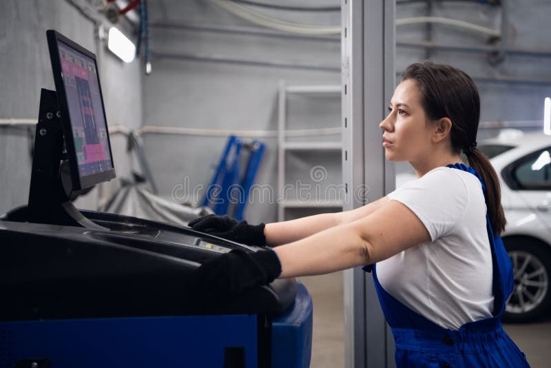 Mechanic Uses a Computer in a Garage. Side View Stock Photo - Image of ...