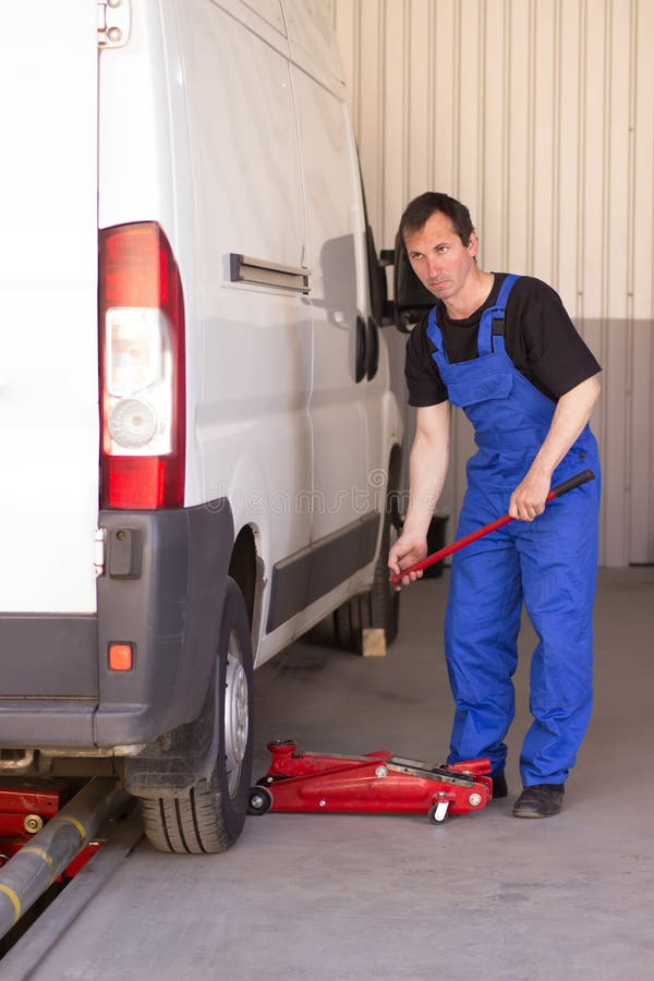 Mechanic uses jackscrew stock photo. Image of active - 125088888