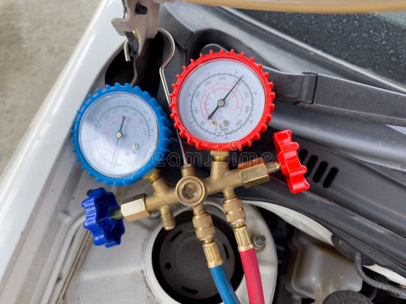 Mechanic Using a C Manifold Gauge Set To Check Air Condition System ...