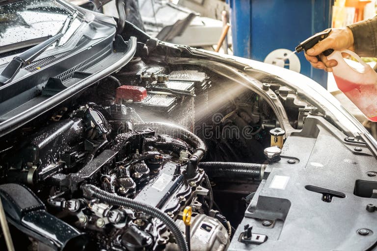 The Mechanic is Using a Cleaning Spray To Clean the Engine Compartment ...
