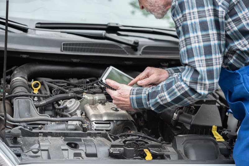 Mechanic Using Digital Tablet for Checking Car Engine Stock Photo ...