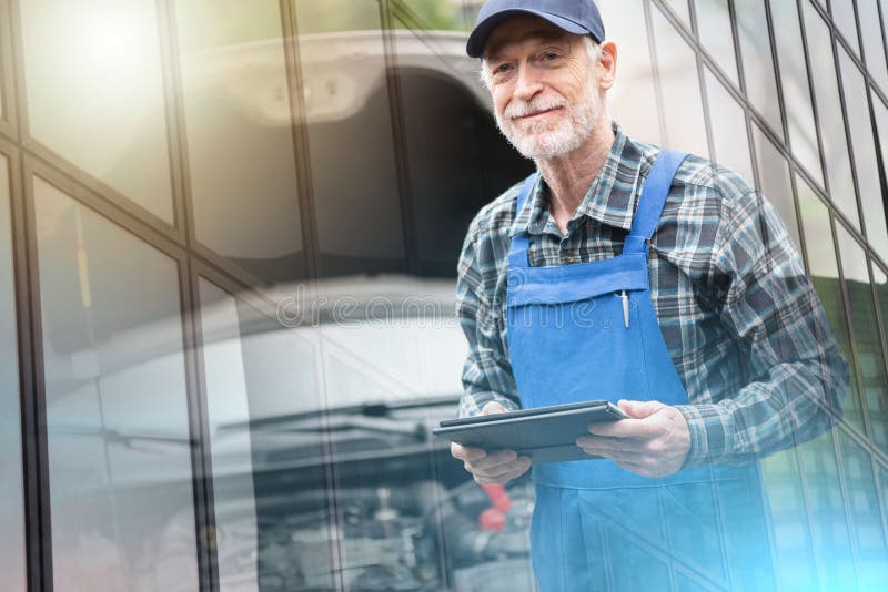 Mechanic Using Digital Tablet for Checking Car Engine; Multiple ...