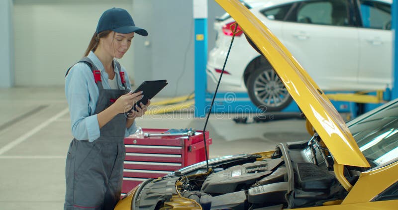 Mechanic Using a Digital Tablet while Doing Routine Maintenance Check ...