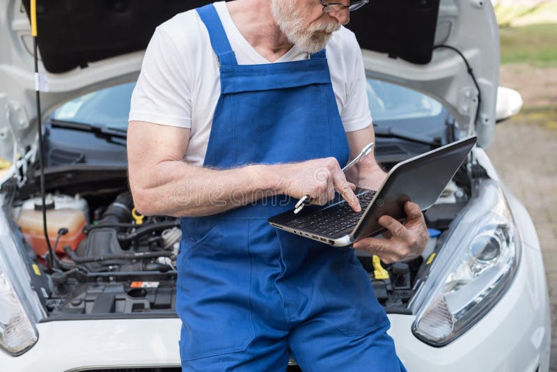 Mechanic Using Laptop for Checking Car Engine Stock Photo - Image of ...