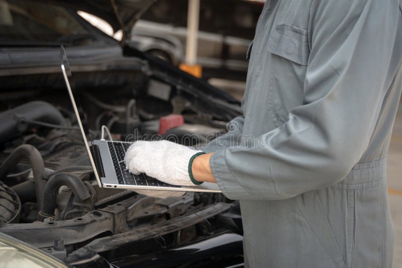 Mechanic Using a Laptop Computer To Check Collect Information during ...