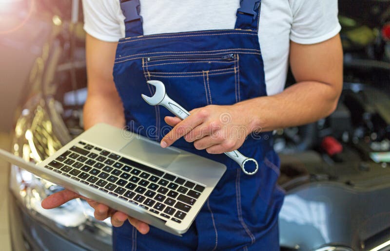 Mechanic Using Laptop while Examining Car Engine Stock Photo - Image of ...