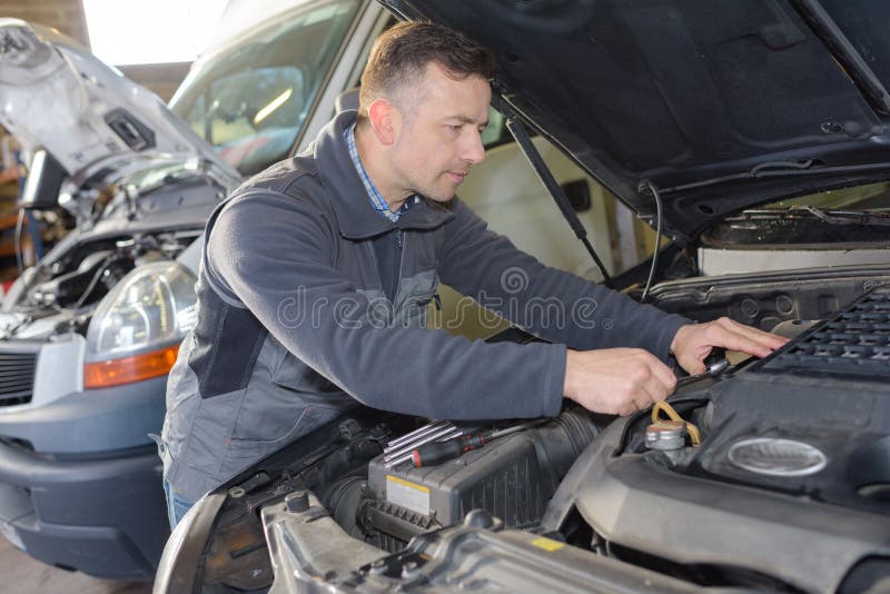 Mechanic Using Laptop while Repairing Car in Garage Stock Photo - Image ... Mechanic Using Laptop while Repairing Car in Garage Stock Photo - Image ...