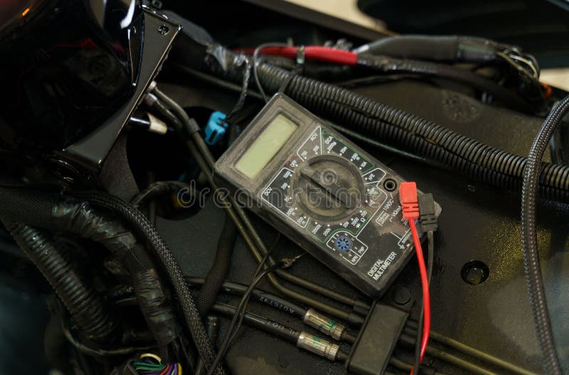 A Mechanic Using a Multimeter Checks the Voltage Level on a Motorcycle ...