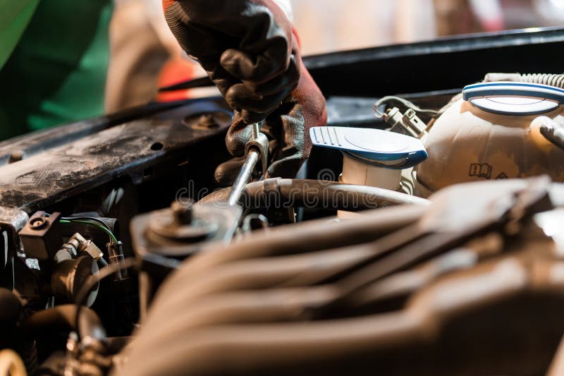 Mechanic Using Socket Wrench Underneath Car Hood for Engine Repair ...