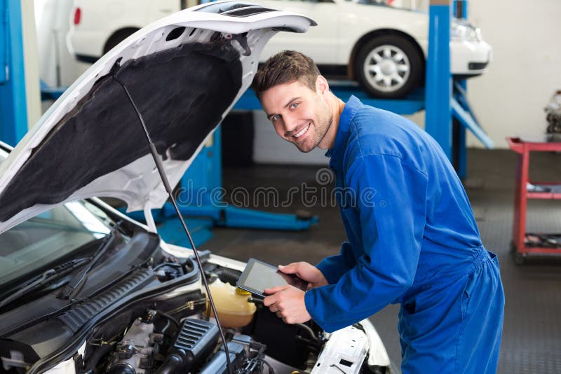 Mechanic Using Tablet To Fix Car Stock Photo - Image of blue, indoors ...