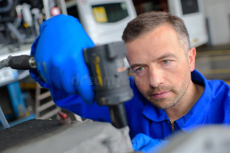 Mechanic using tool stock image. Image of project, workwear - 174512761