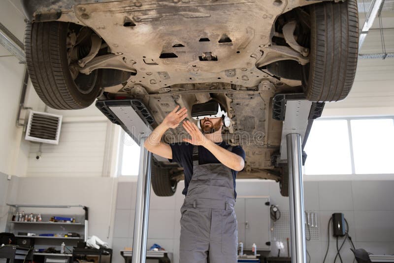 Mechanic Using Virtual Glasses Examining Car on Lift in Garage Stock ...