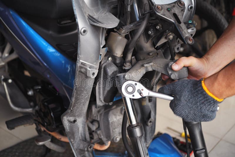 Mechanic Using a Wrench and Socket on the Engine of a Motorcycle ...
