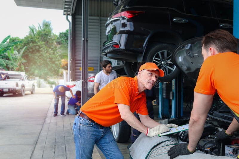 Mechanic Workers Working with Engine at Garage, Car Service Technician ...