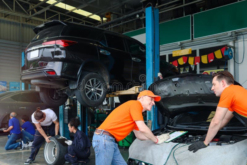 Mechanic Workers Working with Engine at Garage, Car Service Technician ...