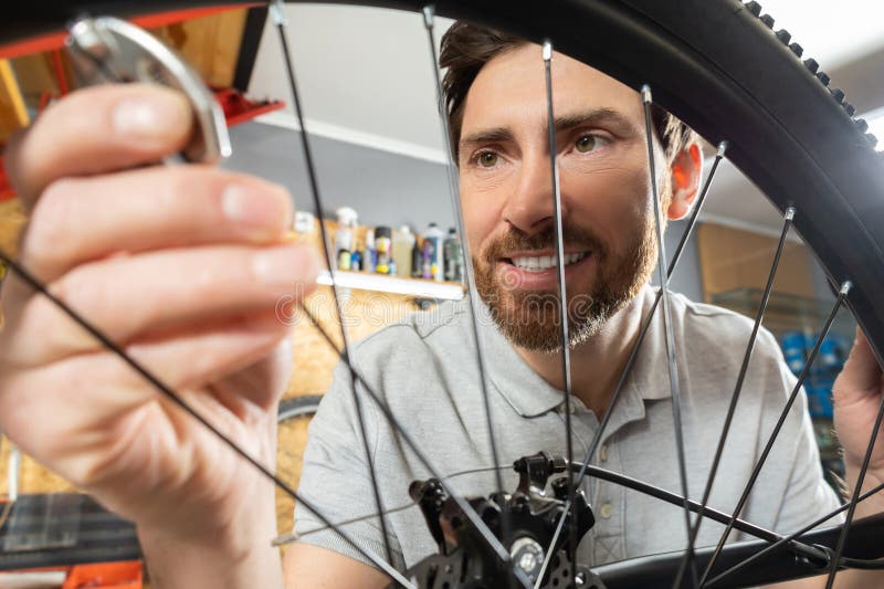 Mechanic Working on Bicycle Wheel in Workshop Stock Photo - Image of ...