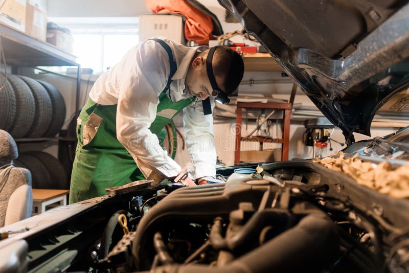 Mechanic Working on a Car Engine in a Garage Stock Image - Image of ...