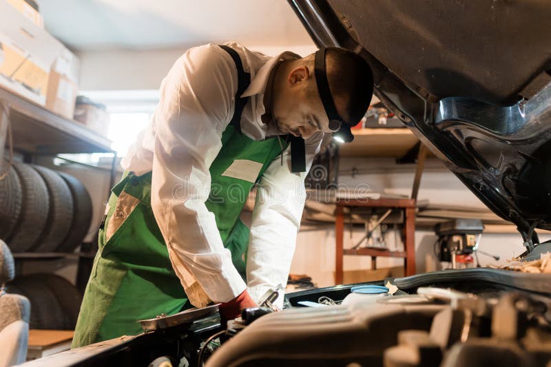 Mechanic Working on a Car in a Well-Equipped Garage Stock Photo - Image ...
