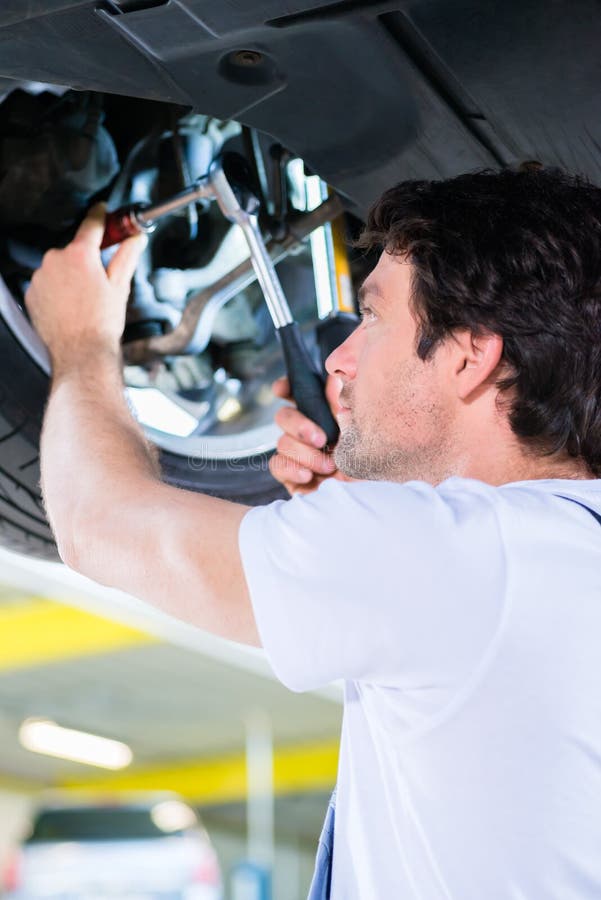 Mechanic Working in Car Workshop on Wheel Stock Photo - Image of wheel ...