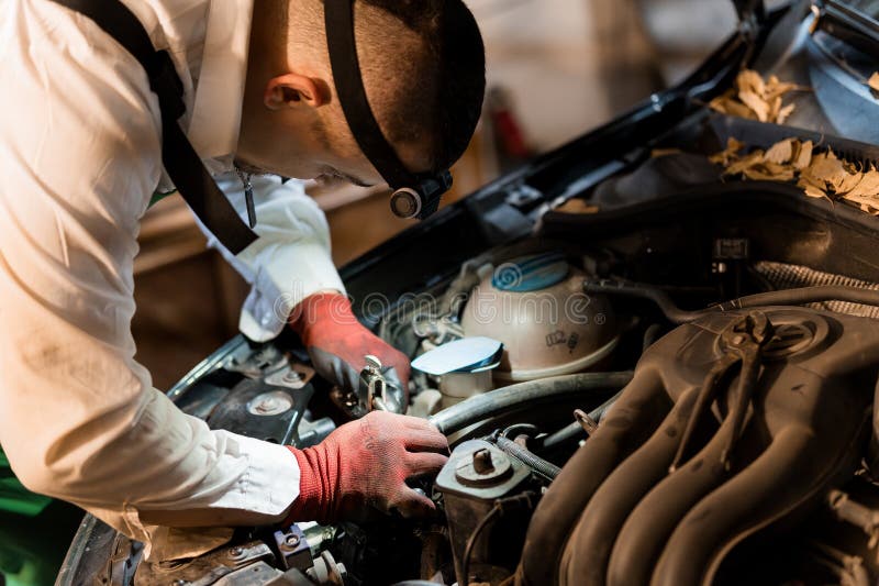 Mechanic Working Diligently on a Car Engine in a Garage Stock Image ...