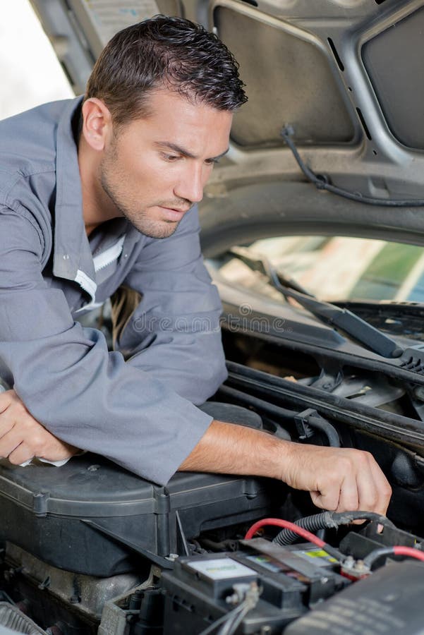 Mechanic working on engine stock photo. Image of person - 124010956