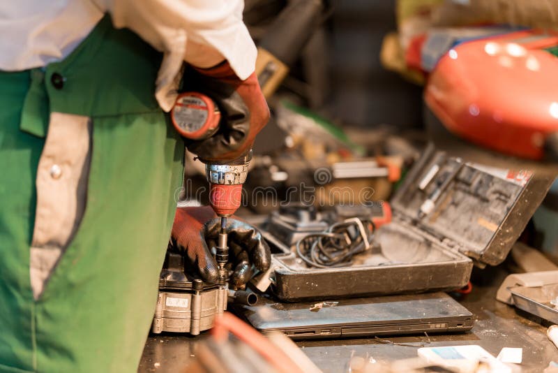 Mechanic Working on Equipment with Power Tools in a Workshop ...