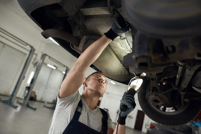 Mechanic Working with Flashlight Under Machine Bottom Stock Photo ...
