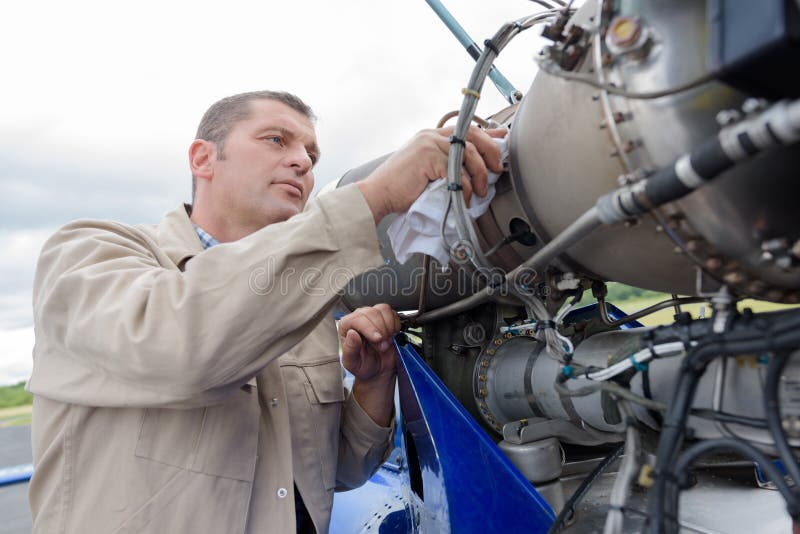 Mechanic Working on Helicopter Outdoors Stock Photo - Image of ...