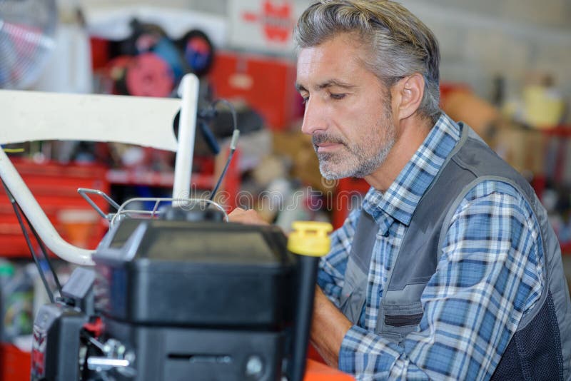Mechanic Working on Lawnmower Stock Photo - Image of fitter, workshop ...