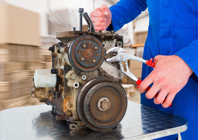Mechanic Working on Machine Against Blurry Boxes Stock Image - Image of ...