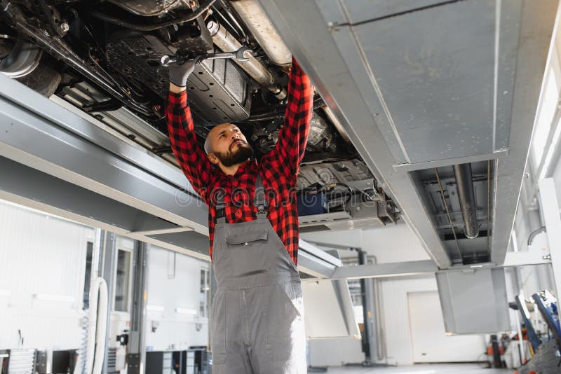 Mechanic Working Under Car at the Repair Garage. Auto Mechanic Working ...