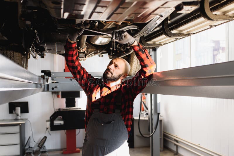Mechanic Working Under Car at the Repair Garage. Auto Mechanic Working ...