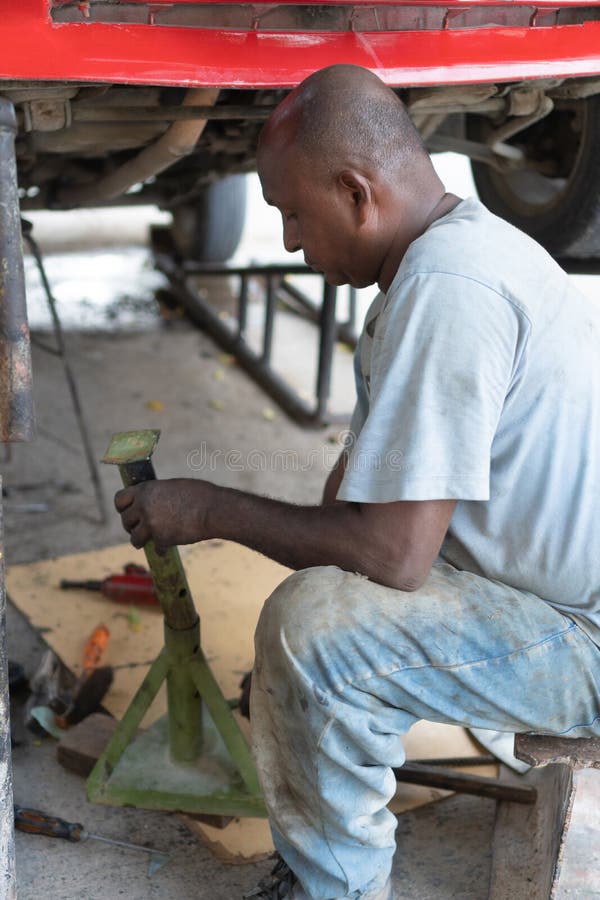 Mechanic Working Under the Vehicle in a Workshop Stock Image - Image of ...