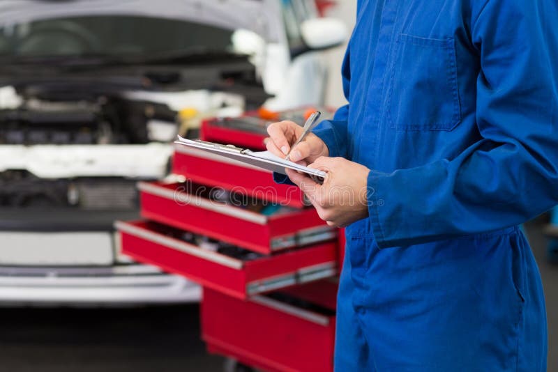 Young Mechanic Engineer Taking a Note on Clipboard for Examining Stock ...