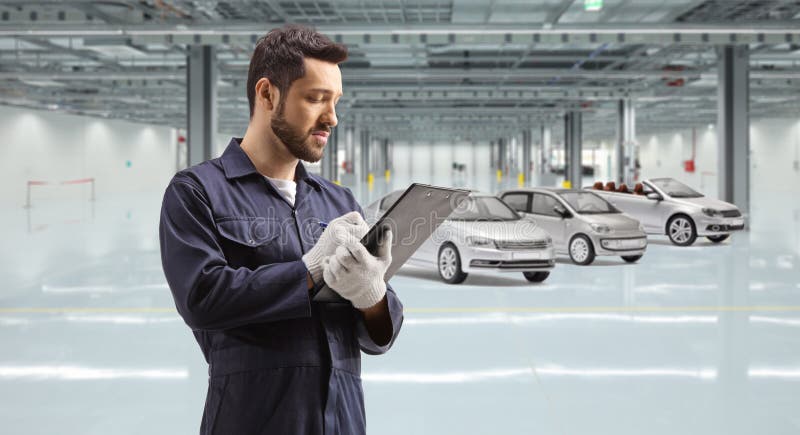 Mechanic Writing a Document in a Automotive Workshop Stock Photo ...