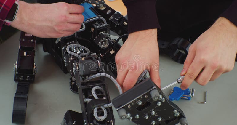 Mechanical Assembly of the Robot Using a Screwdriver. Hands of a ...