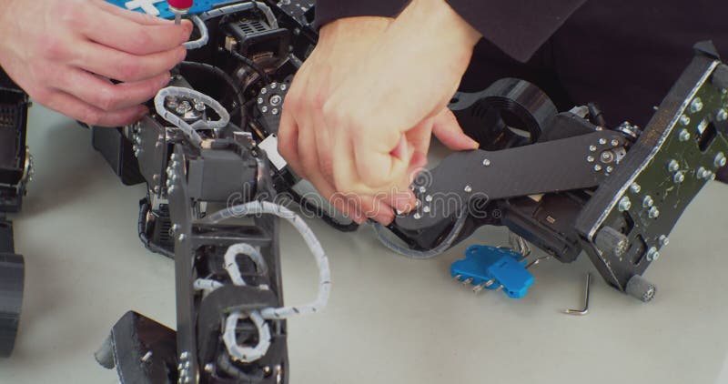 Mechanical Assembly of the Robot Using a Screwdriver. Hands of a ...