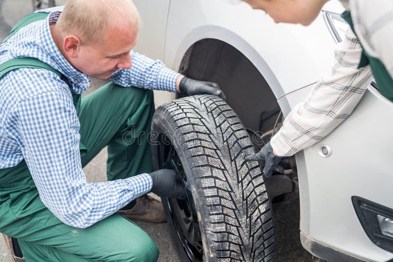 Mechanics Changing Wheel of a Car at Service Stock Photo - Image of ...