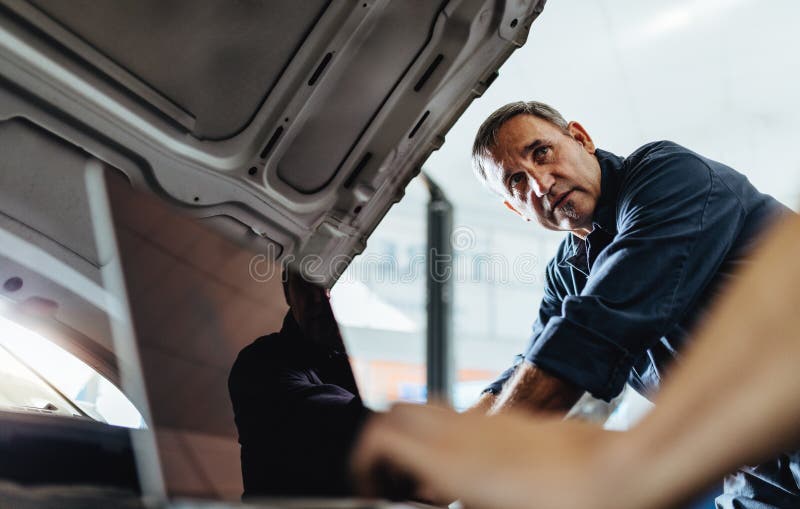 Mechanics Working on a Broken Car in Garage Stock Image - Image of ...