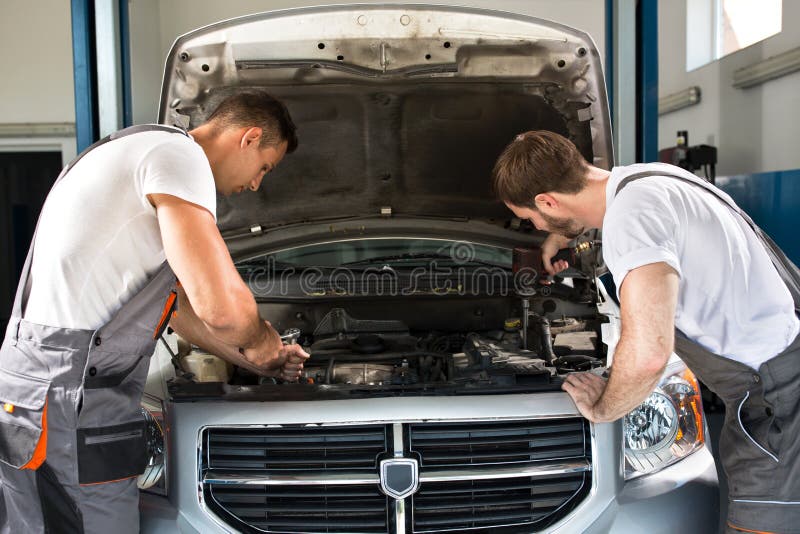 Mechanics working together stock image. Image of auto - 75368709