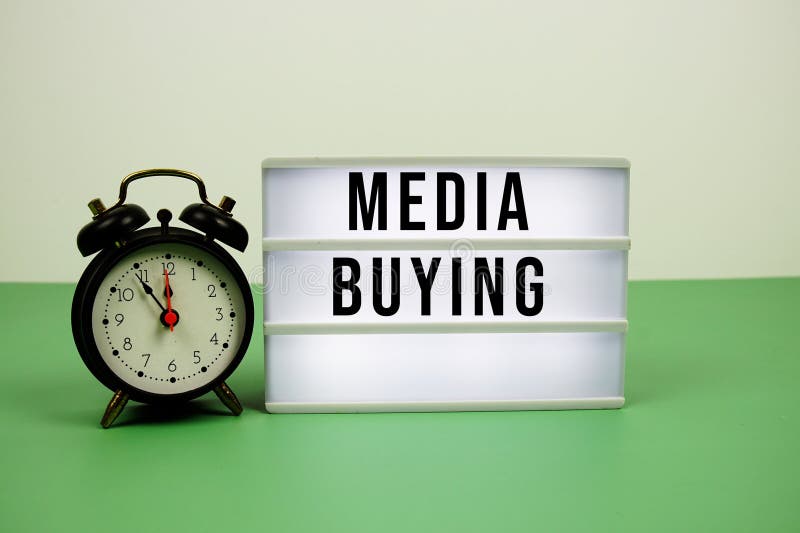 Media Buying Text on LED Lightbox with Alarm Clock on Green Background ...