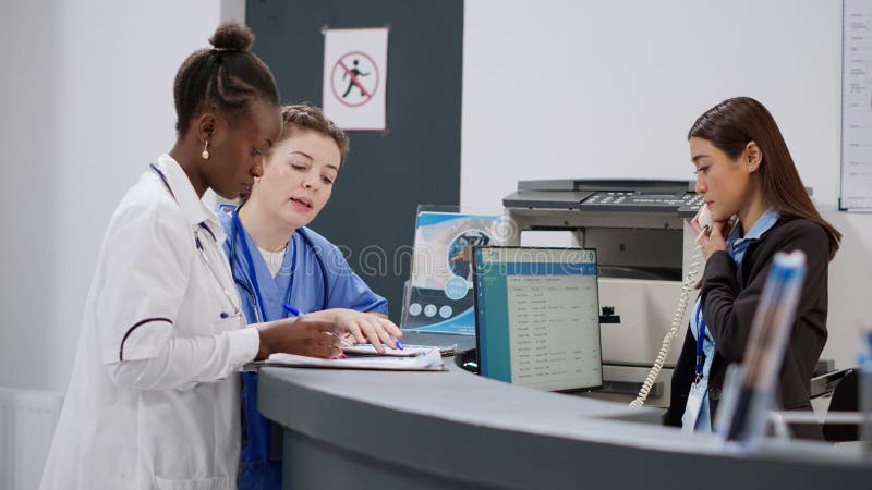 Medical Assistant and Doctor Analyzing Report Papers at Reception ...