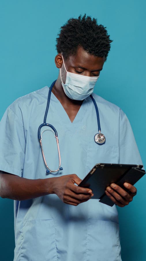 Medical Assistant Using Digital Tablet while Wearing Face Mask Stock ...