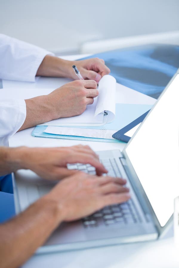 Medical Colleagues Working with Laptop and Taking Notes Stock Photo ...