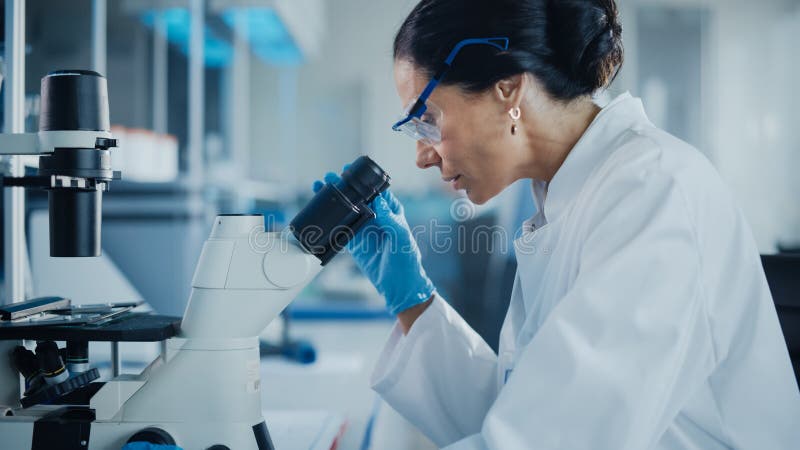 Medical Development Laboratory: Female Scientist Looking Under ...