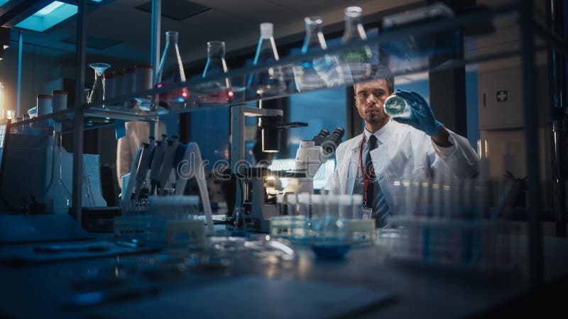 Medical Development Laboratory: Scientist Using Microscope, Analyzes ...