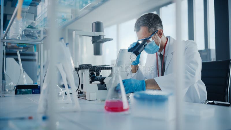 Medical Development Laboratory: Scientist Wearing Face Mask Looking ...