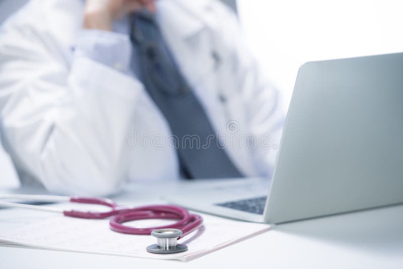 Medical Doctor Working on Computer in Examination Room Stock Photo ...